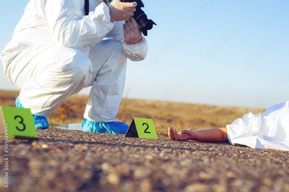 Detective studying a crime scene taking photographs. Stock Photo ...
