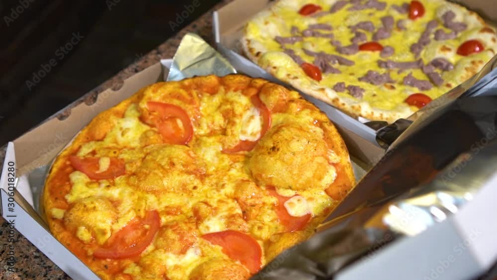 Pizza is placed in a cardboard box for further delivery. Order pizza ...