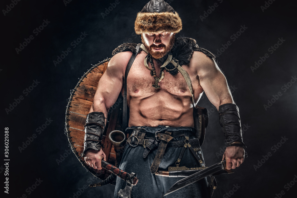 Severe barbarian in warrior clothes, posing on a dark background. Stock ...
