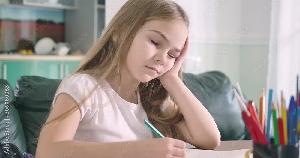 Portrait of tired Caucasian schoolgirl yawning and holding head with ...