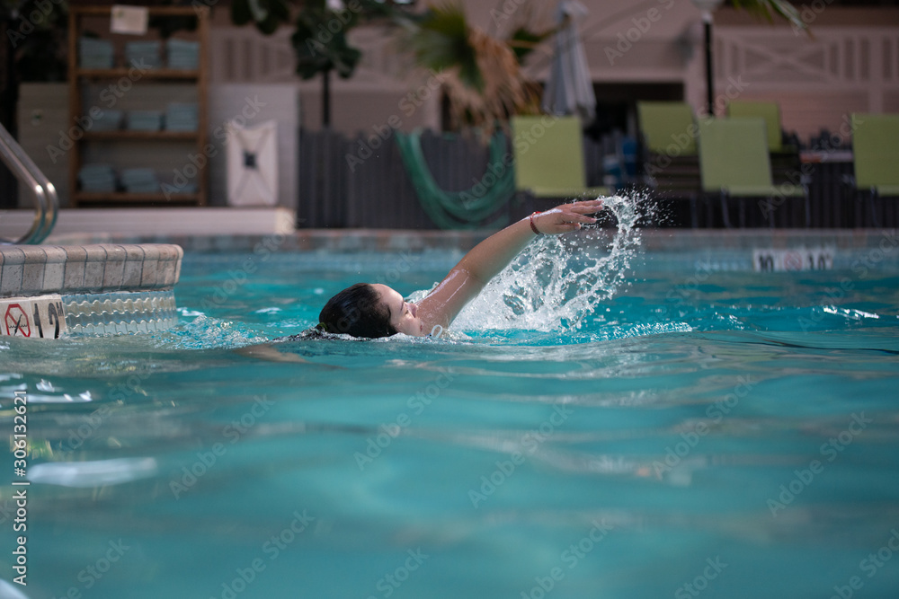 Teen Girl swimming in an indoor pool. Teen healthy lifestyle concept ...