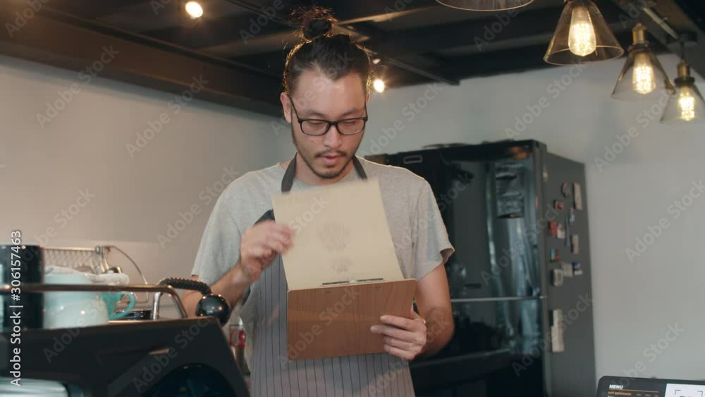 Portrait young Asian guy barista take receive order with menu feeling ...