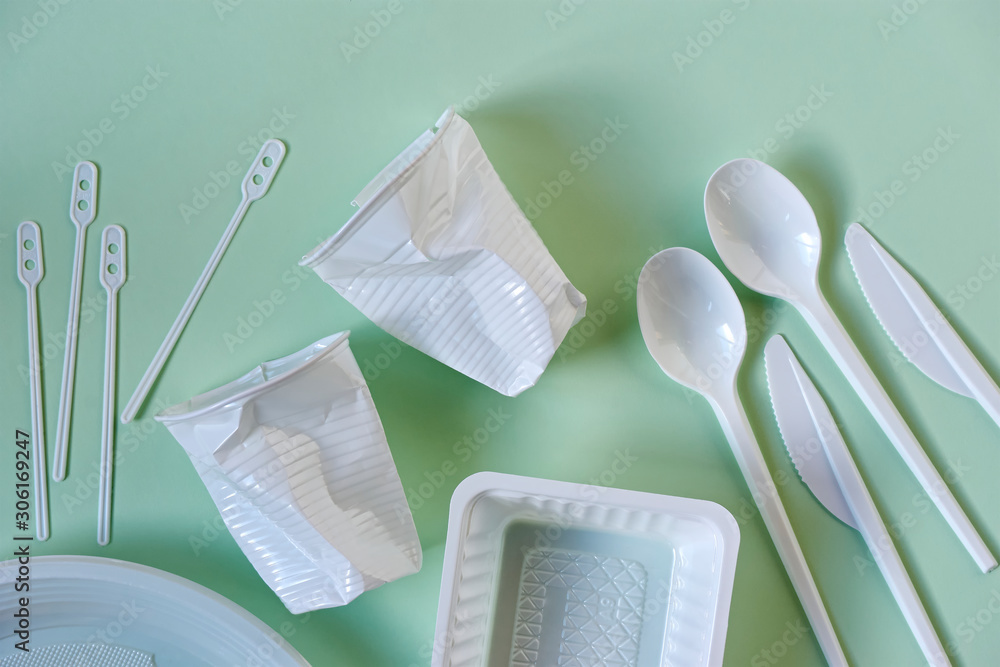 Two smashed white plastic coffee cups, spoons, knives, stirrers, plate ...