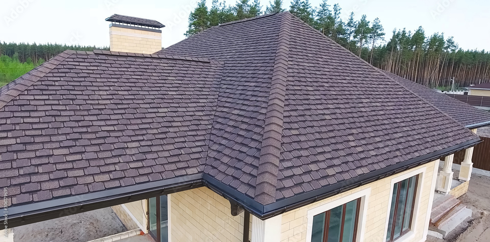 Bituminous tile for a roof. House with a roof from a bituminous tile. a ...