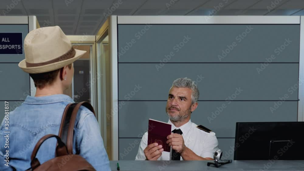 Airport security customs officer checks passport to a woman traveler ...