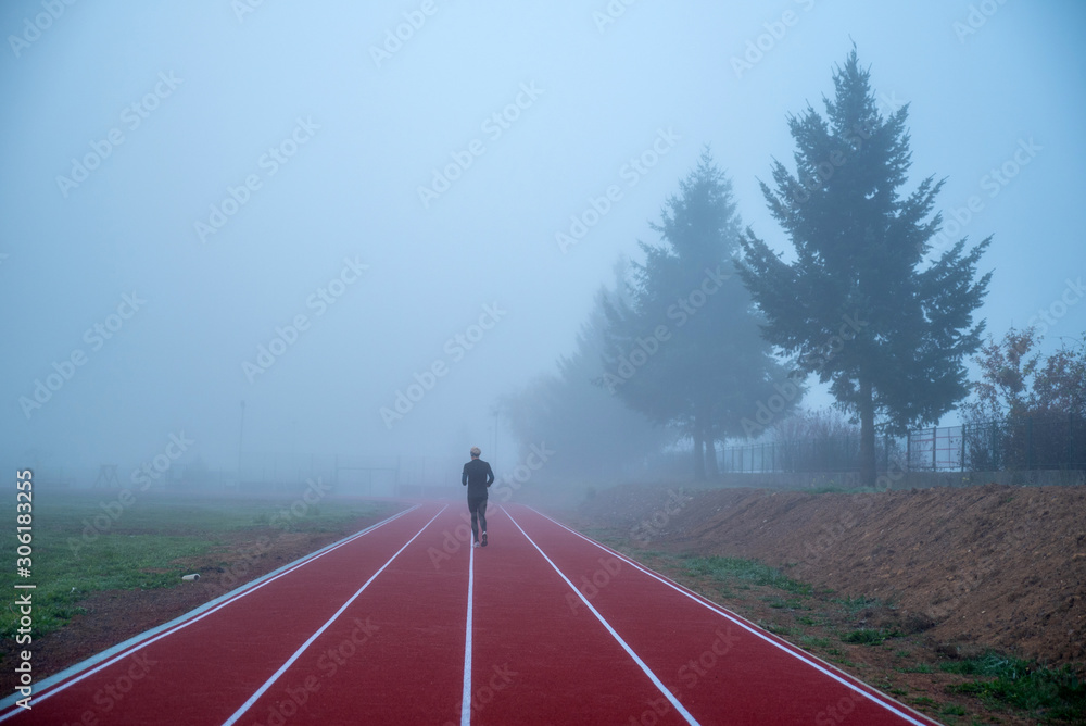 Professional athlete train at athletics running track in morning blue ...