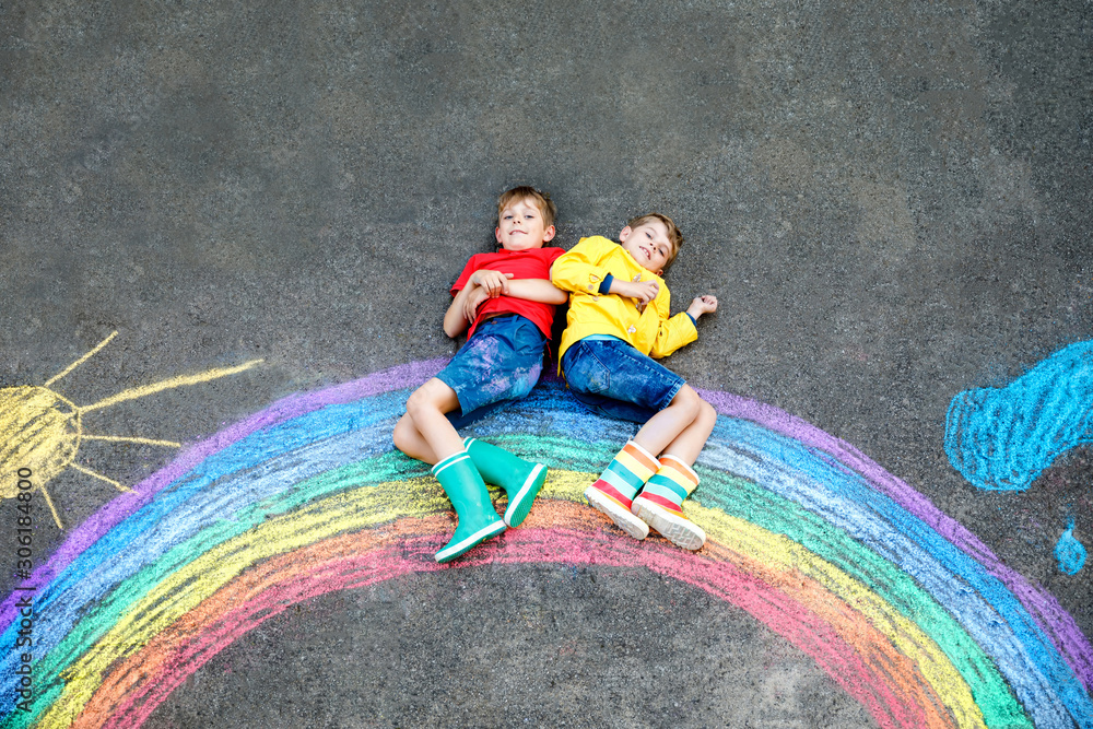 two school kids boys having fun with with rainbow picture drawing with ...