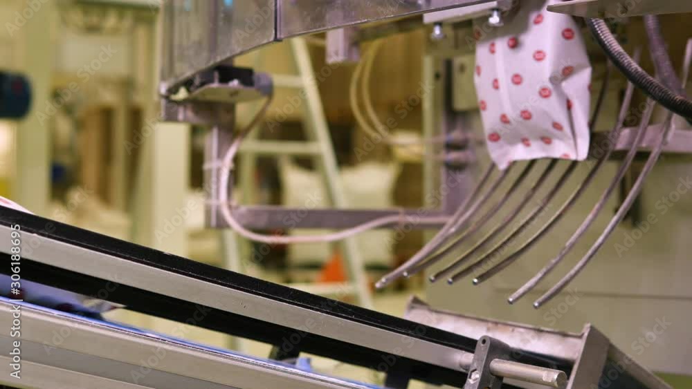 White plastic food bags falling on a conveyor belt in a bakery factory ...