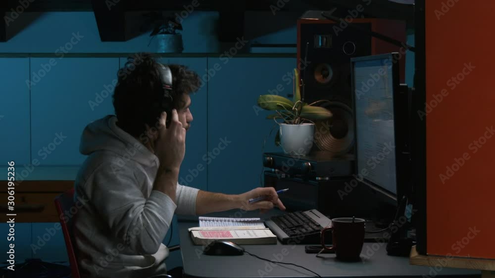 slowmotion Portrait of young student studying on computer in dark room ...