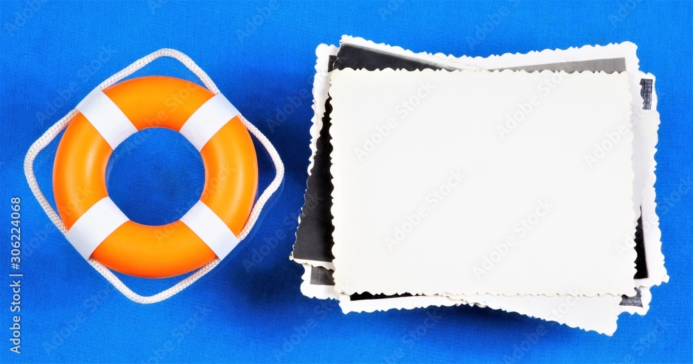Old photos and marine life preserver on the water, orange float ...