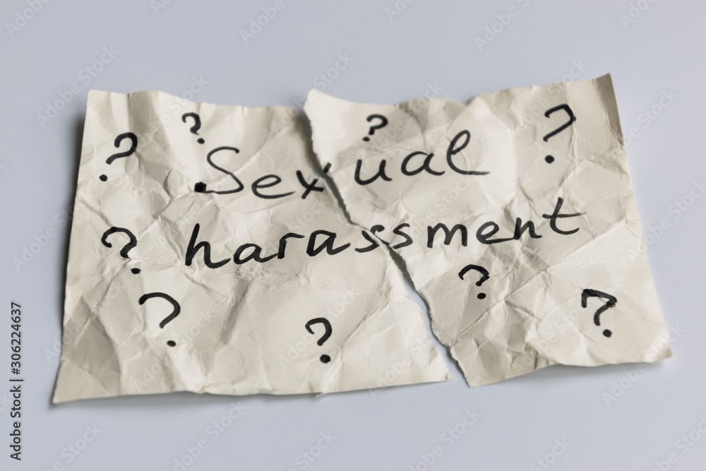 Sexual harassment concept. A torn piece of crumpled paper with many ...