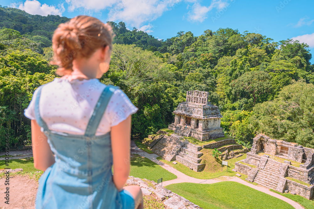 Young woman walking through the ancient Mayan ruins of Palenque ...
