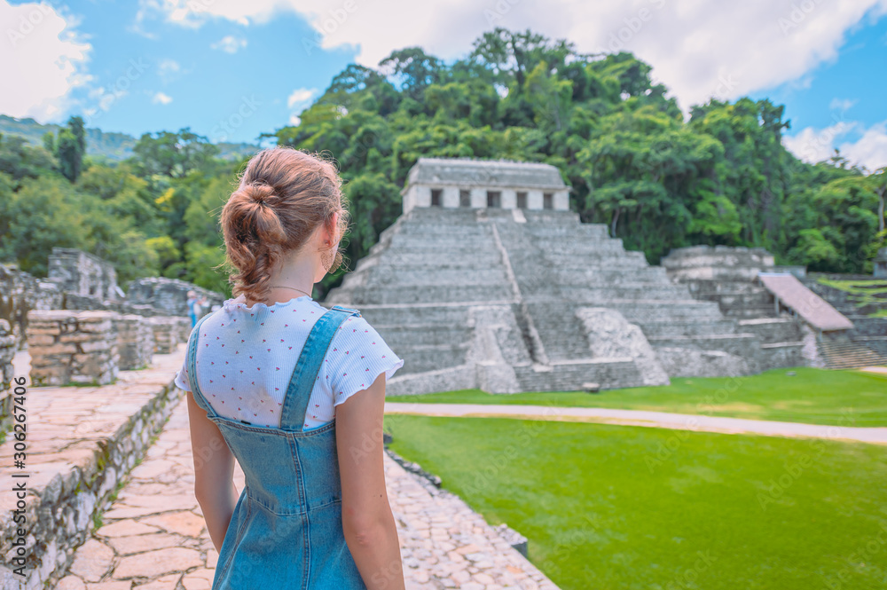 Young woman walking through the ancient Mayan ruins of Palenque ...