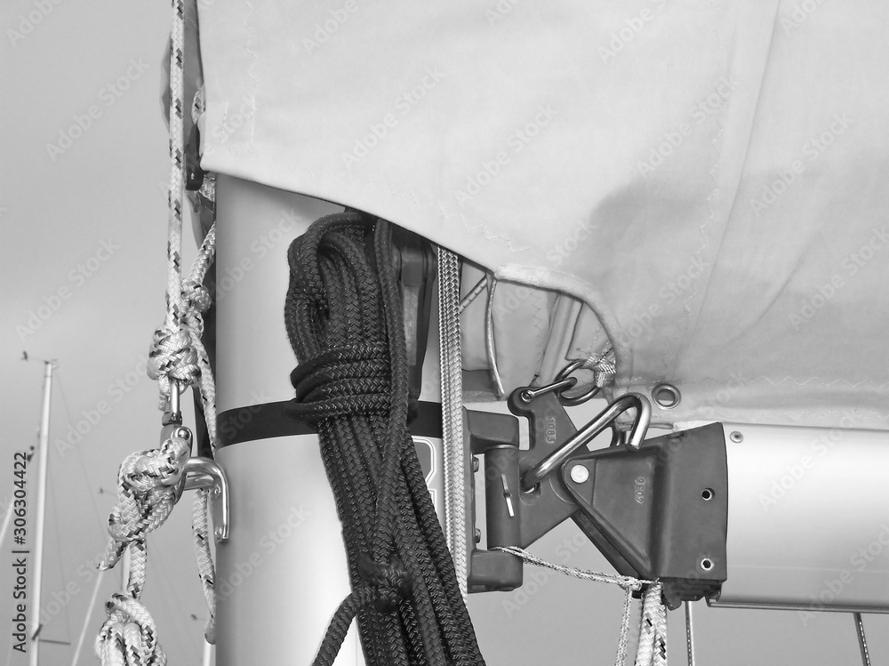 Organised links between mast and boom on a sailsboat. The halyard and ...