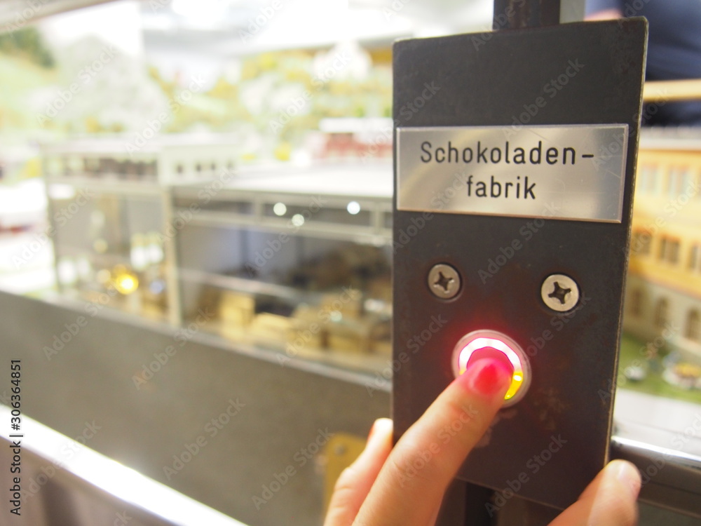 A woman's hand pushing the activation button of a miniature chocolate ...