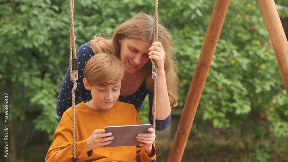 Mom and son look at the tablet screen Stock Video | Adobe Stock