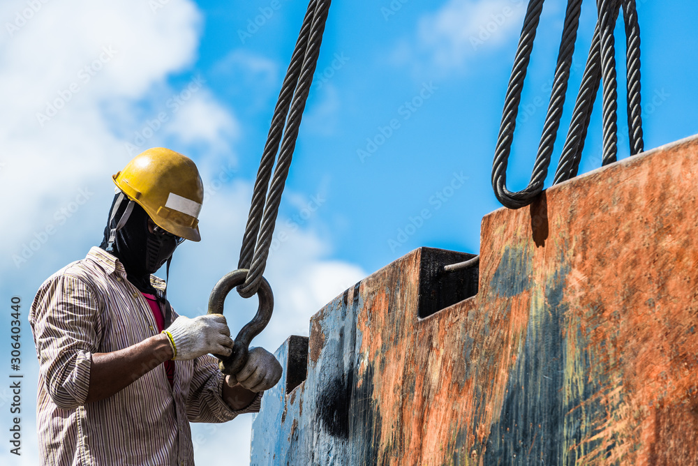 Technician rigger checking crane hook sling safety before lifting heavy ...