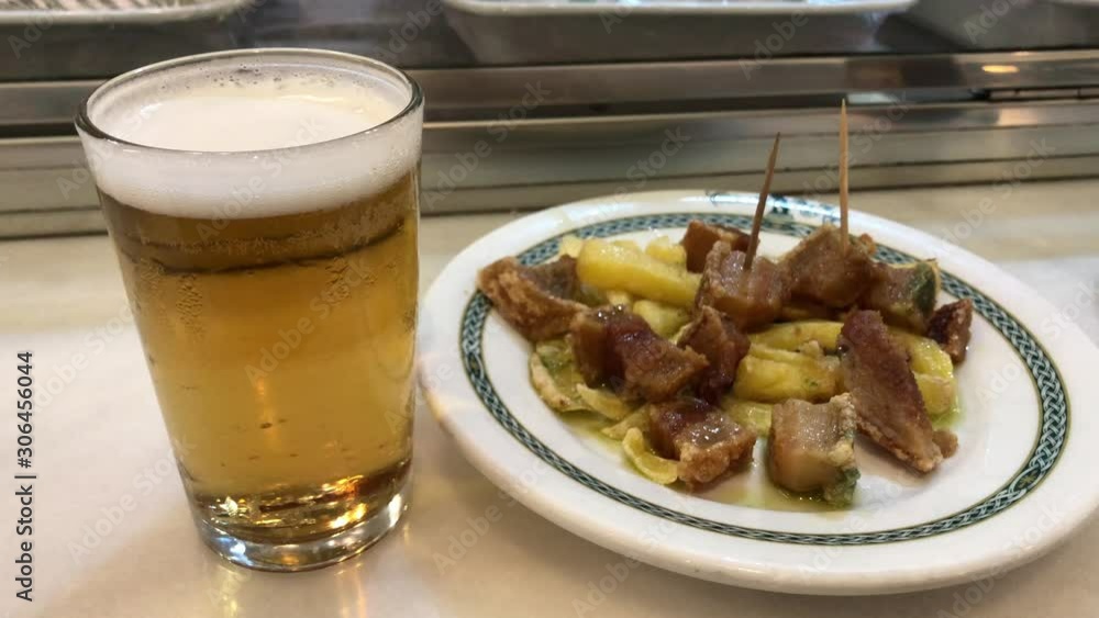 Beer glass with tapas food, typical in Spain. Beer and tapa on a bar ...