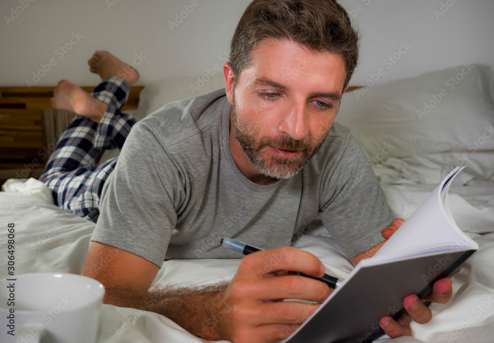 lifestyle portrait of young attractive and relaxed man at home lying ...