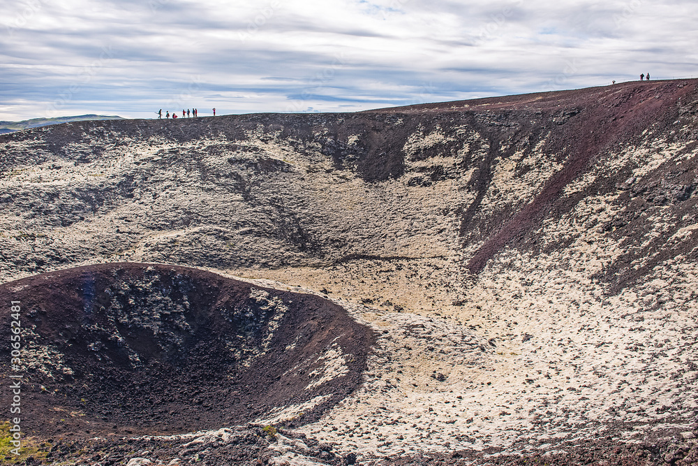 large double bowl volcanic crater; dormant volcano; a group of tourists ...