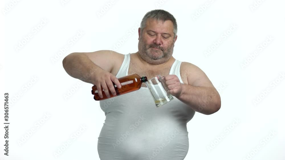 Fat man pours beer from bottle into a beer glass. Obese man with big ...