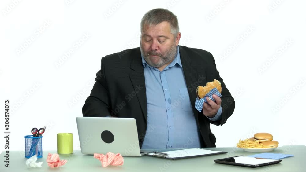 Excessive office worker having an unhealthy snack. Engaged busy ...