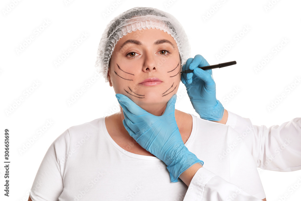 Doctor drawing marks on woman's face for cosmetic surgery operation ...