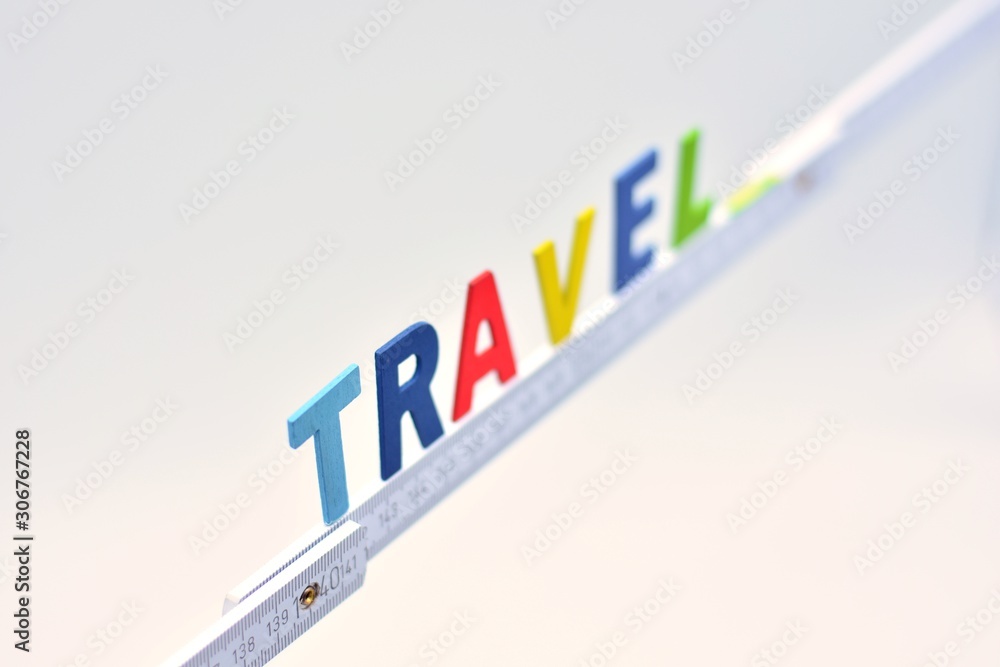 La palabra travel, hecha con letras de madera sobre un metro de ...
