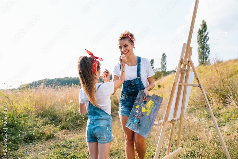 mother teaches daughter paint in park. Sunny nature, mom and daughter ...