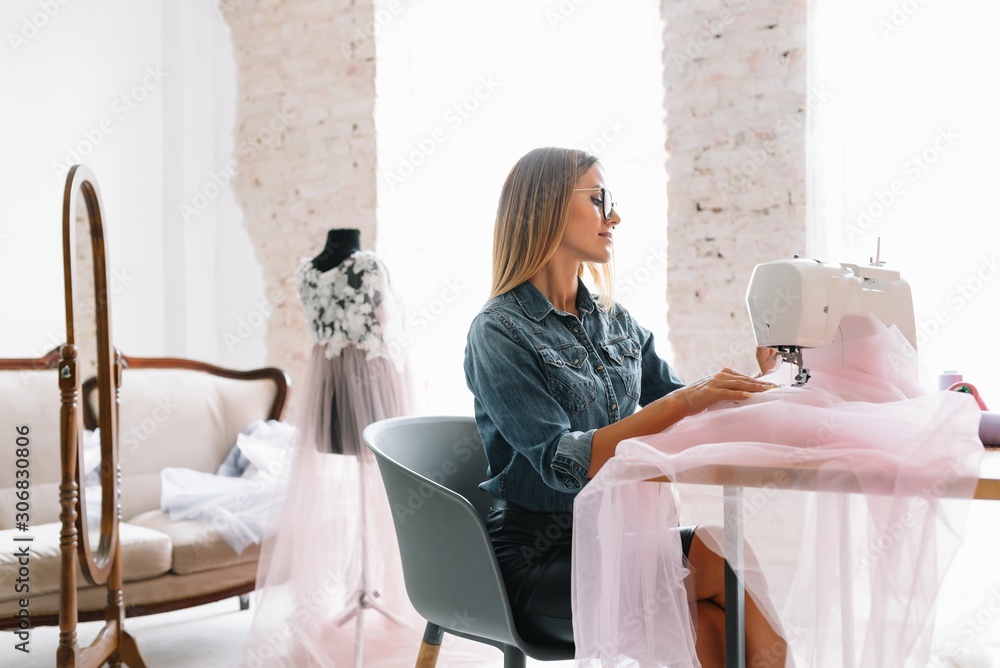 Smiling fashion designer looking at camera at workplace, dressmaker ...