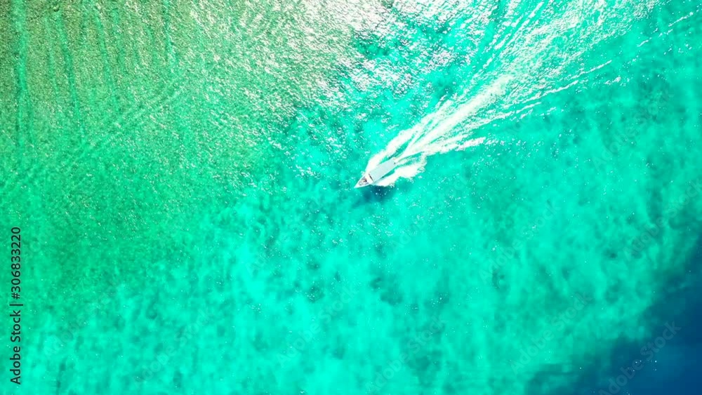 Touring boat tracing across beautiful sea surface textured with green ...