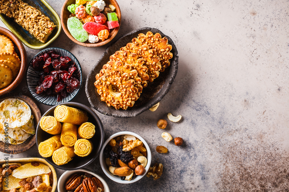 Variety of snacks and sweets on gray background. Waffles, nuts, sweets ...