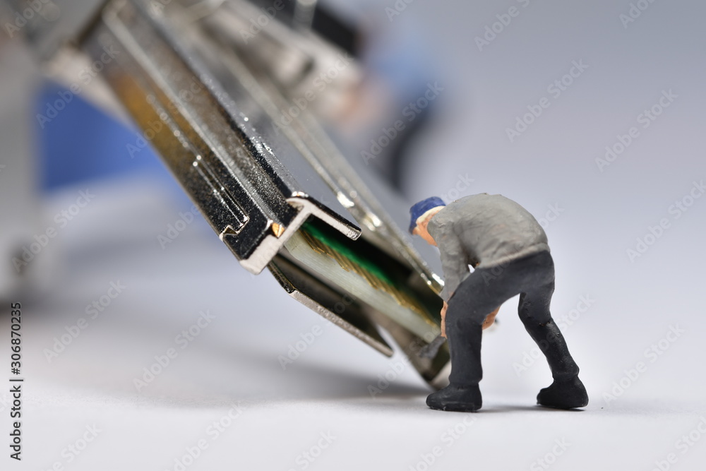 Tiny worker is working on a plug miniature repair scale Stock Photo ...