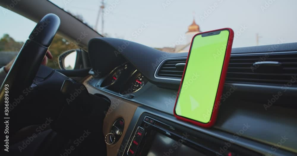 Closeup of green screen smartphone on dashboard car panel with driving ...