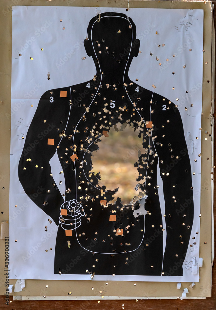 Targets for shooting shaped like a human with bullet holes in body and ...