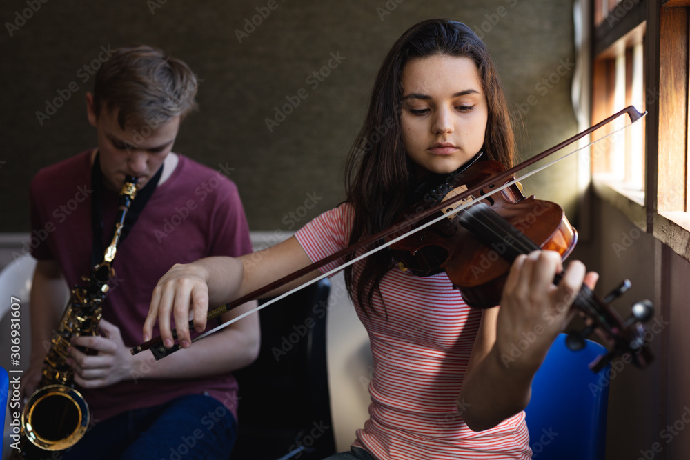 Boy and girl practicing with musical instruments in music school Stock ...