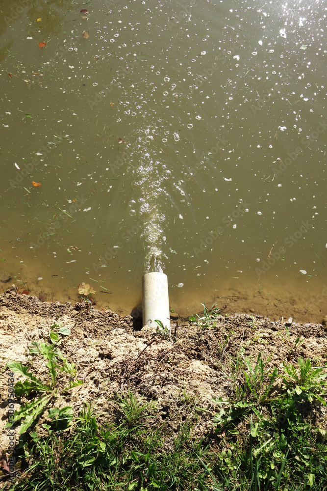 Water inflow through plastic pipe into pond Stock Photo | Adobe Stock
