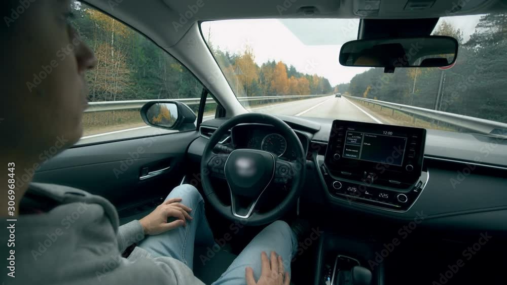 A man sits in a car while it drives on road. Automatic, self-driving ...