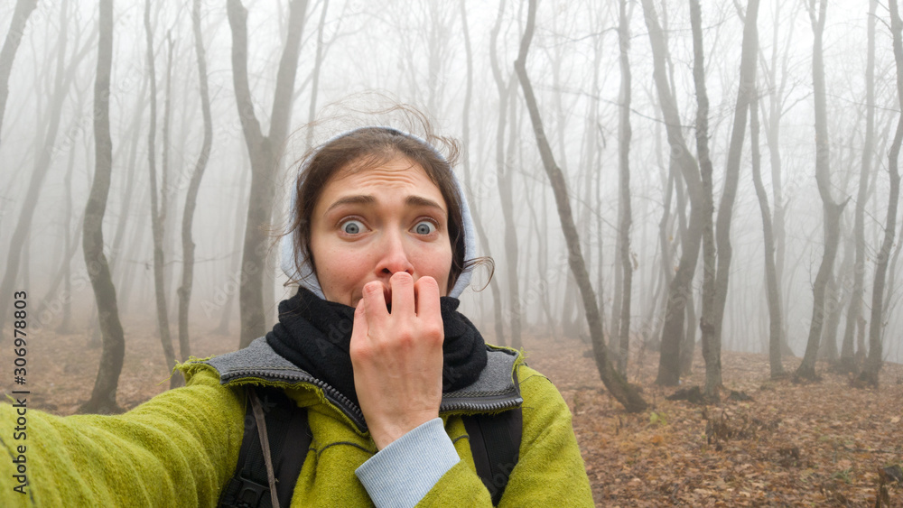 Funny girl traveler while walking through a dangerous foggy forest ...