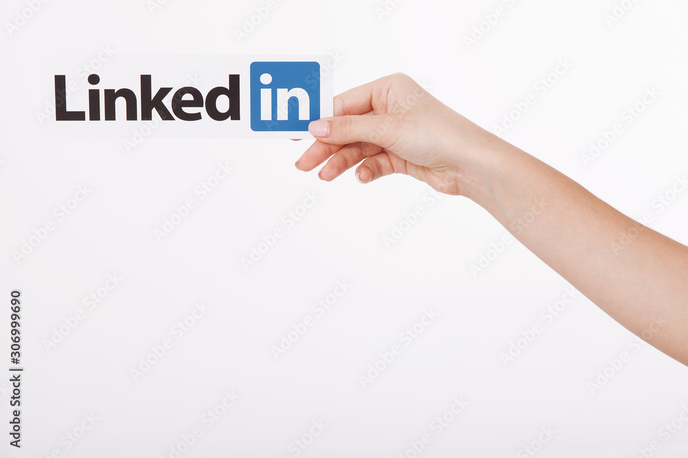 KIEV, UKRAINE - August 22, 2016: Woman hands holding Linkedin logo sign printed on paper on ...