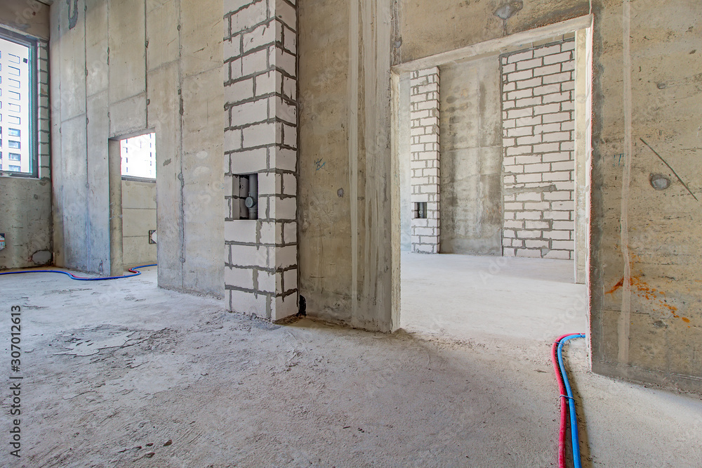 Monolithic brick basement wall. heating pipes lie on floor. New empty ...