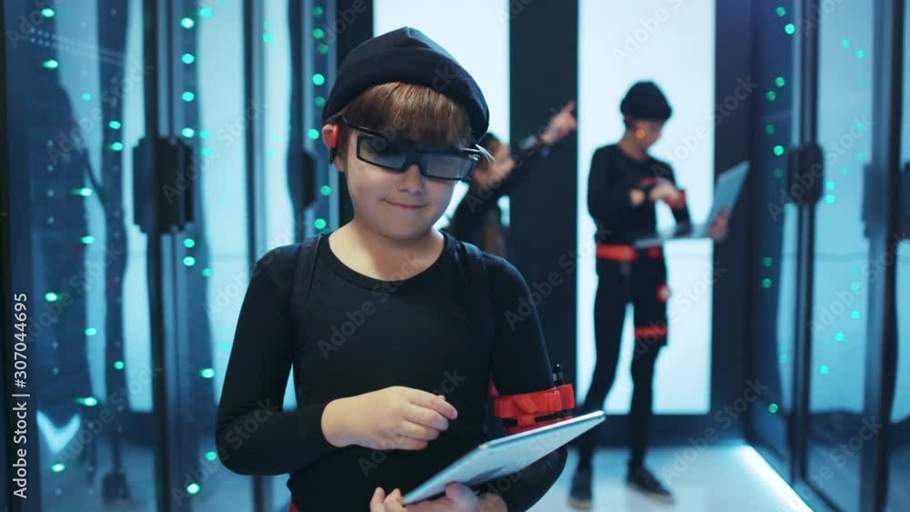 Young boy hacker wearing smart glasses and holding tablet ...