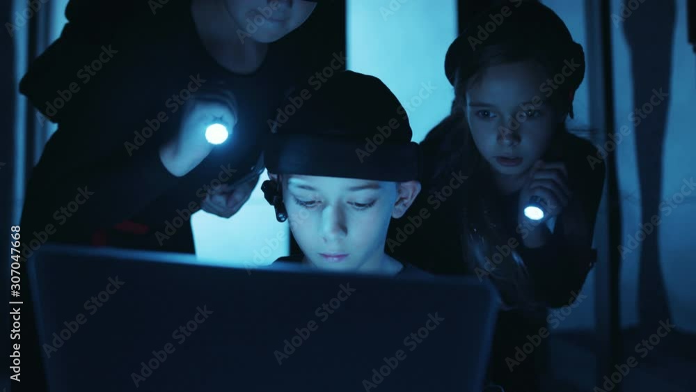 Talented boy hacker coding at laptop monitor hacking a modern database ...