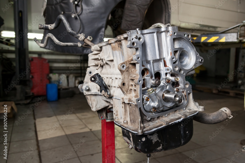 A car raised on a rotary lift for overhaul repair and under it a ...