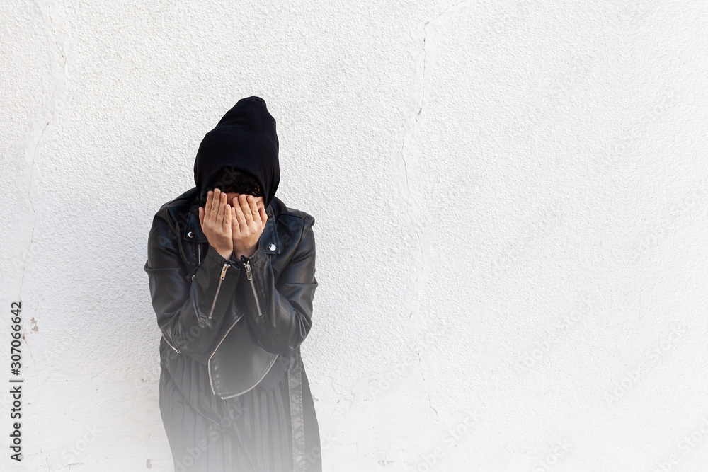 Young Muslim girl covering face with palms. Victim of domestic violence ...
