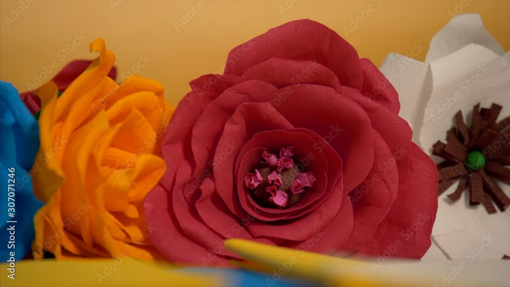 A close up shot of beautifully crafted flowers made from paper. A ...