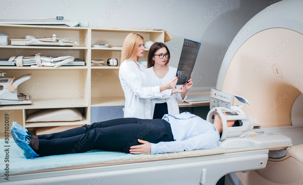 Two female models doctors examining patient and hold a picture in their ...