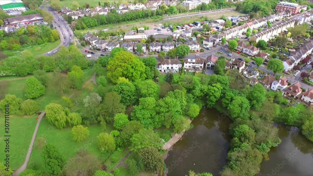 Drone footage over priory park looking at trees and a fishing lake with ...