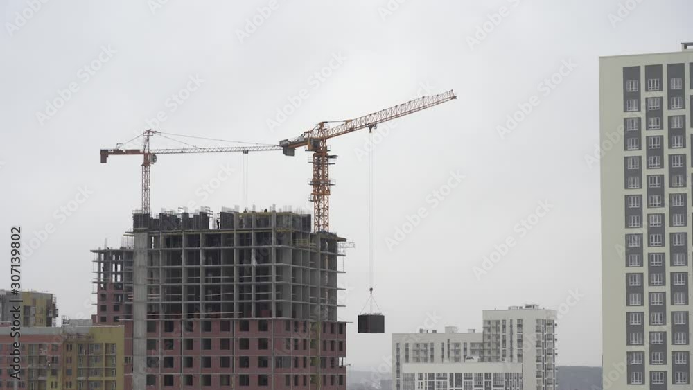 A construction crane lifts a load. Tower Crane on a Construction Site ...