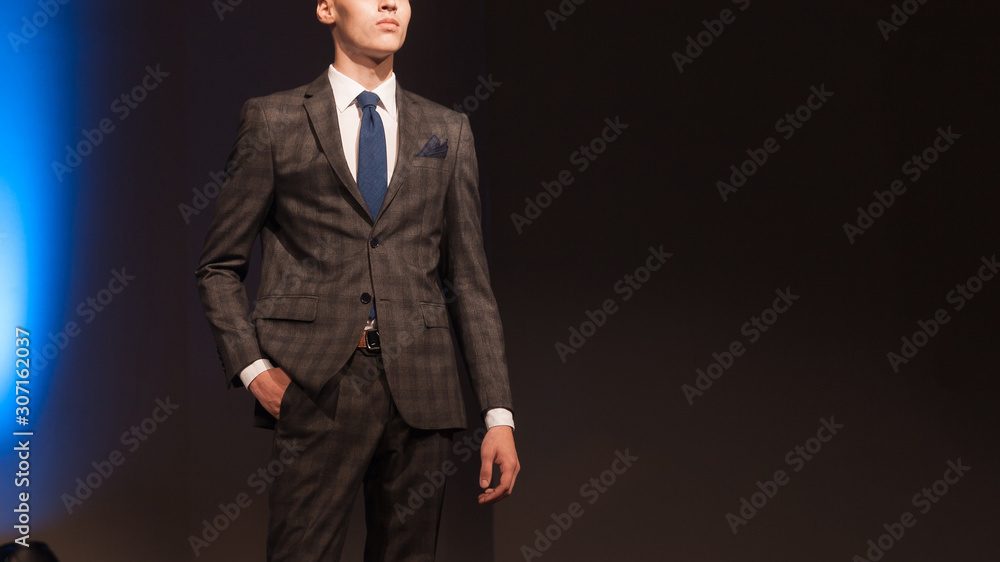 two attractive male models in a stylish suit during a fashion show ...